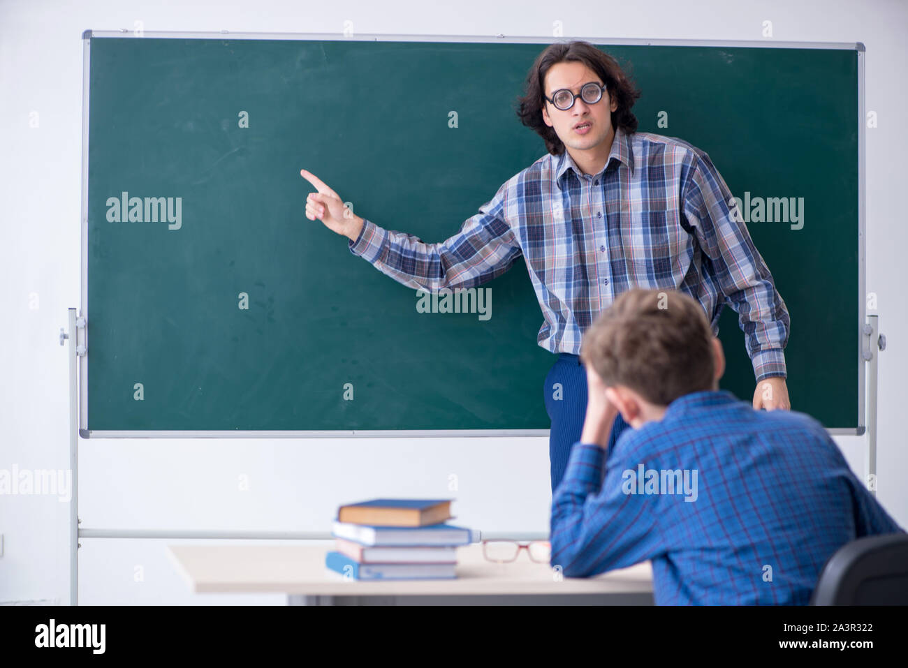 The funny male teacher and boy in the classroom Stock Photo - Alamy