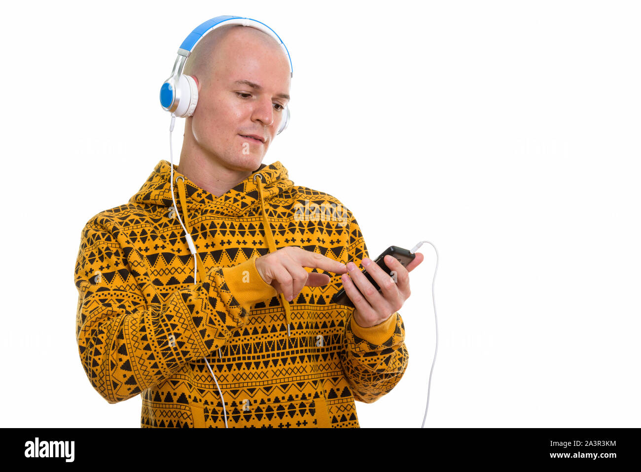 Bald man using phone while wearing headphones Stock Photo - Alamy