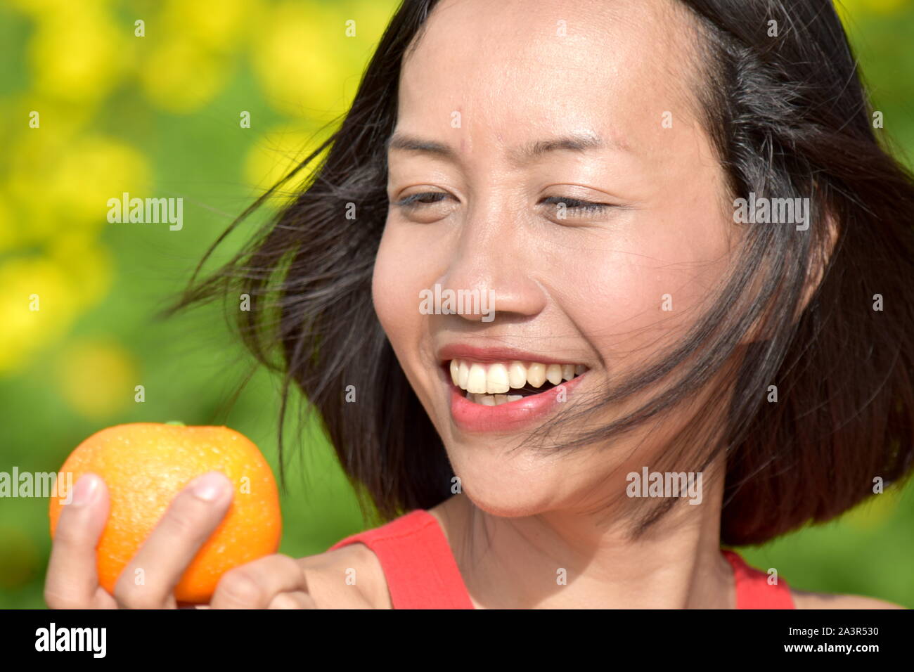 Pretty Asian Female Smiling With Fruit Stock Photo - Alamy