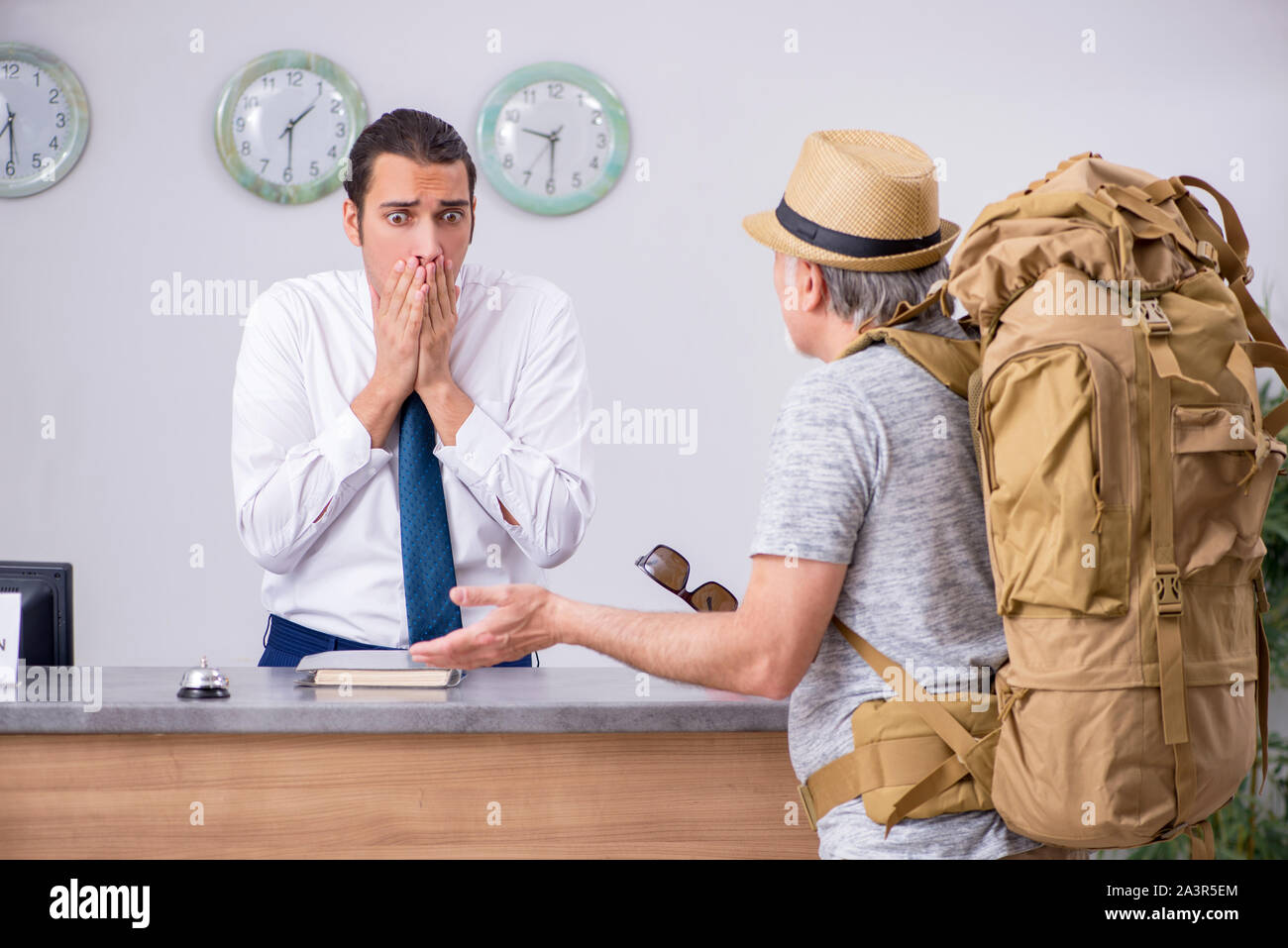 Old backpacker at the hotel reception Stock Photo - Alamy