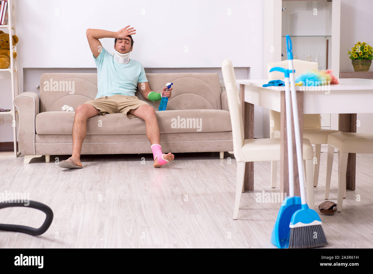 The young injured man cleaning the house Stock Photo - Alamy