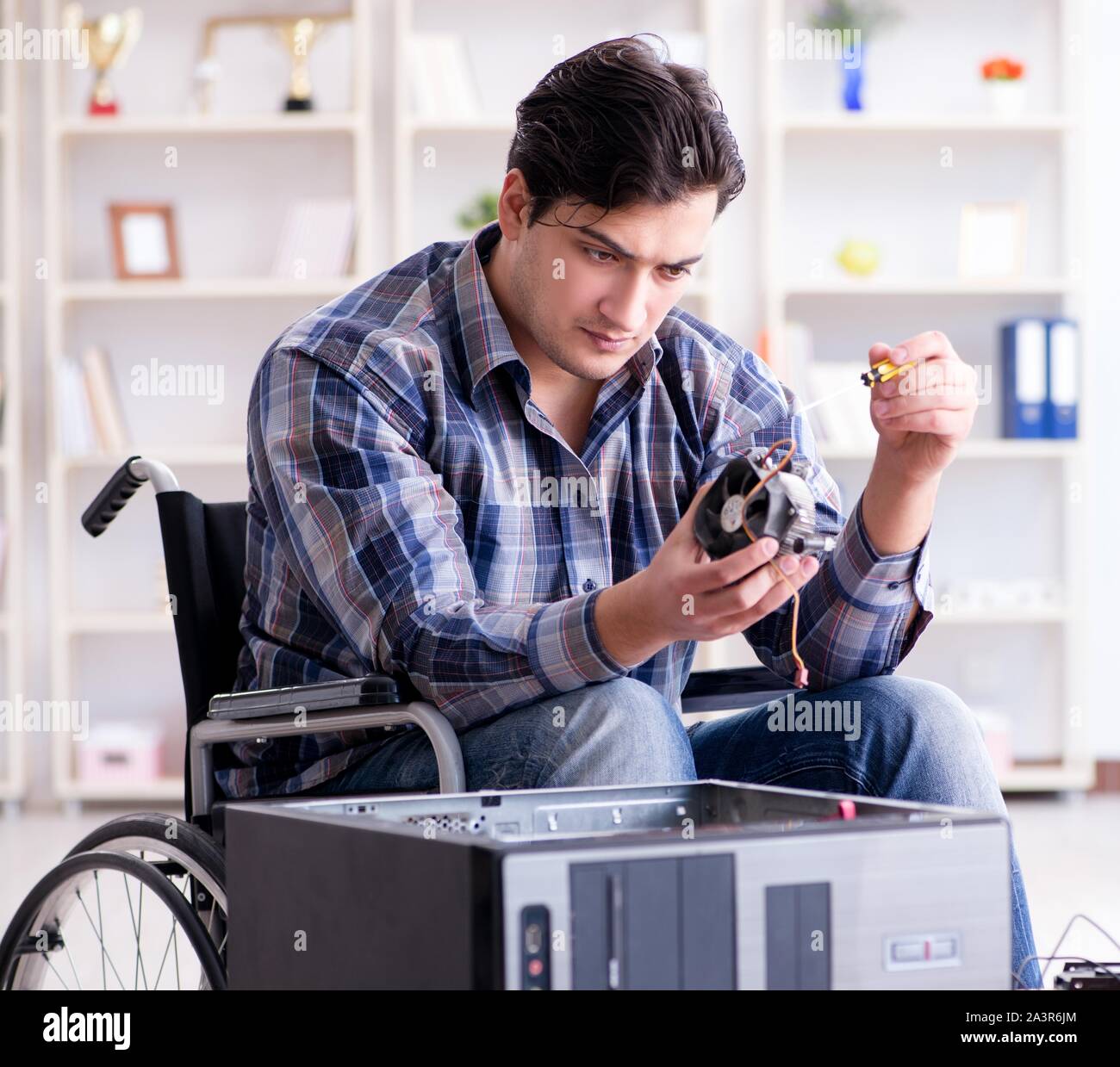 The disabled man on wheelchair repairing computer Stock Photo - Alamy