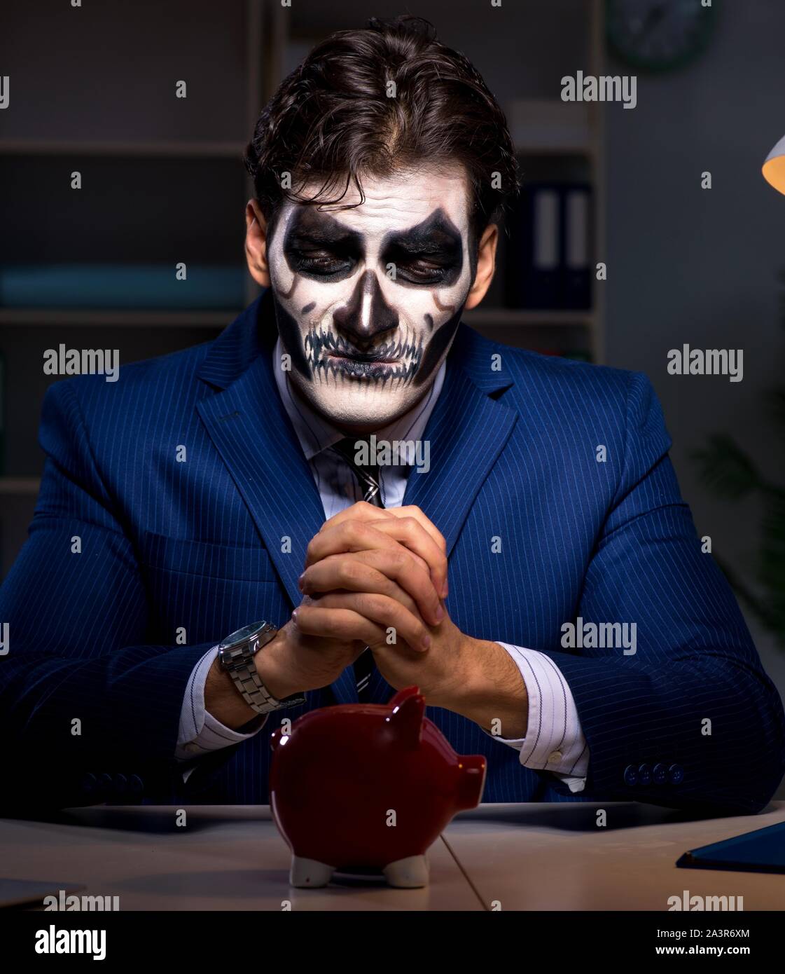 Businessman with scary face mask working late in office Stock Photo - Alamy