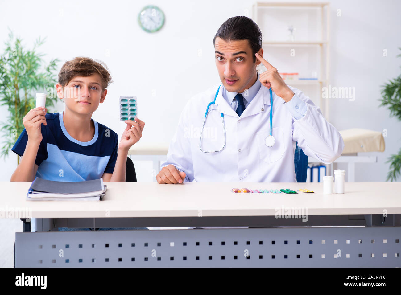 The young male doctor examining boy in the clinic Stock Photo - Alamy