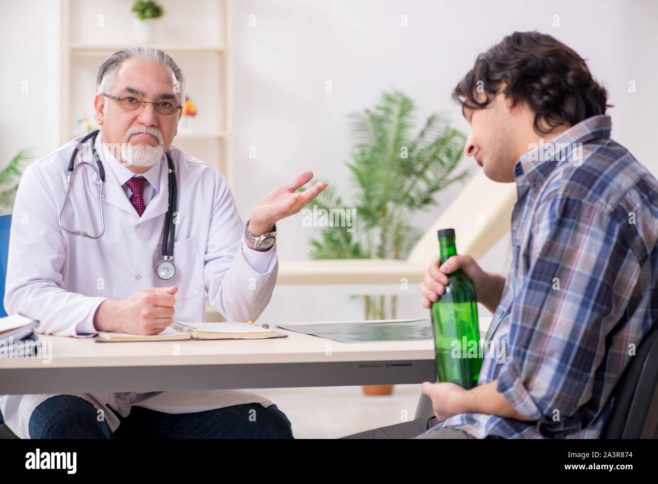 The young male alcoholic visiting old doctor Stock Photo - Alamy