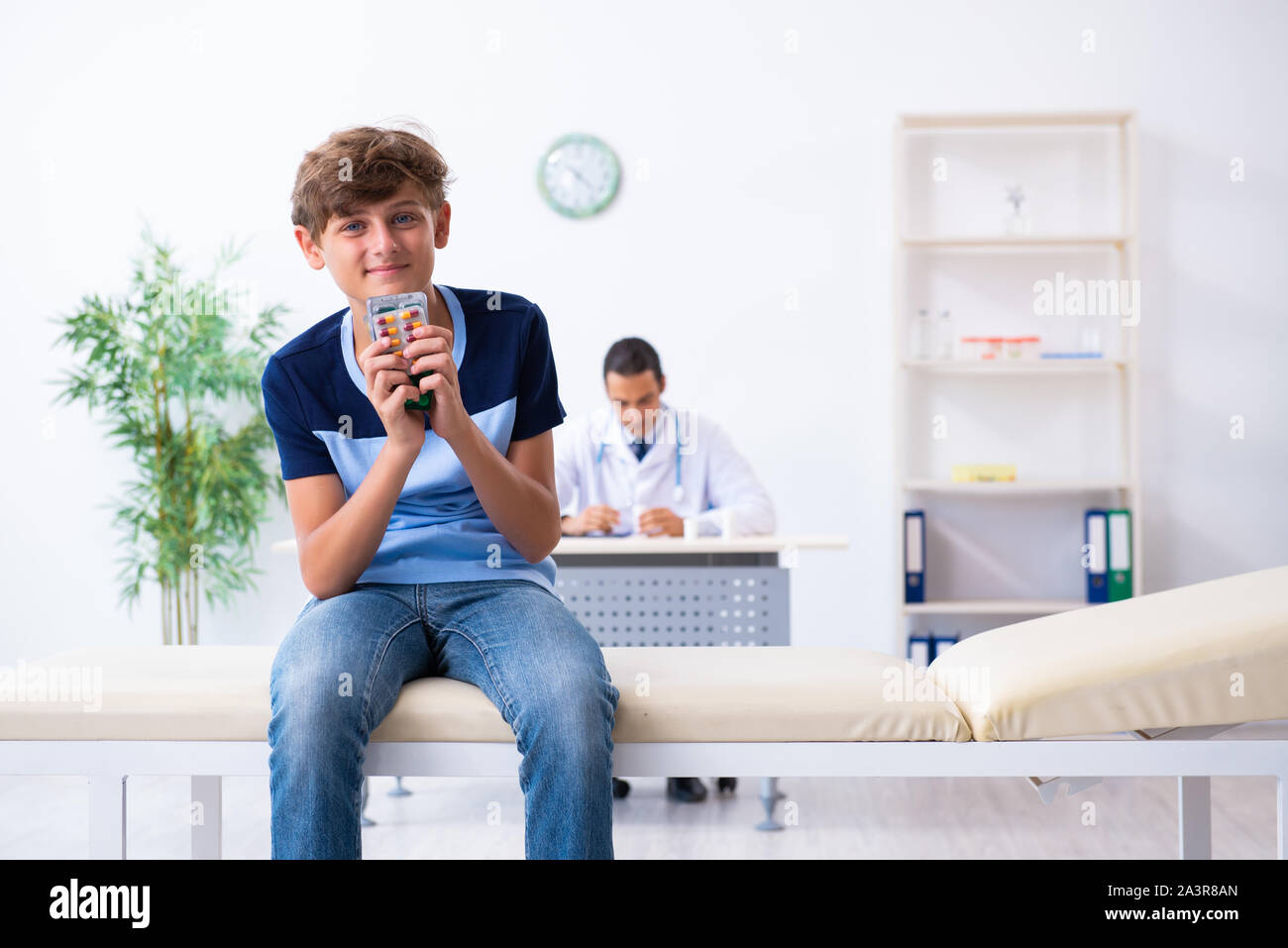 The young male doctor examining boy in the clinic Stock Photo - Alamy