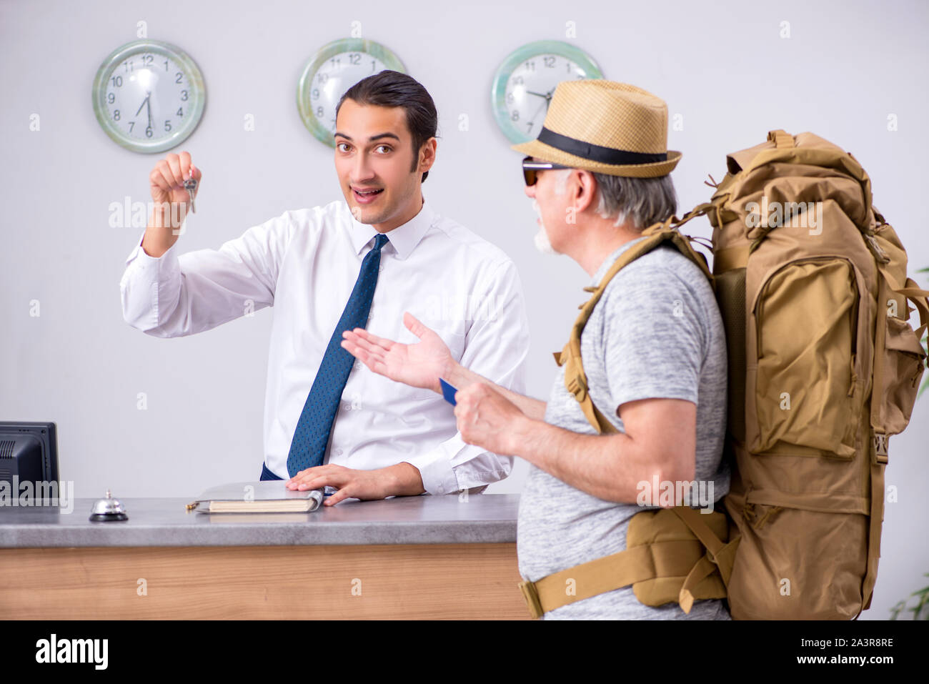 Old backpacker at the hotel reception Stock Photo - Alamy