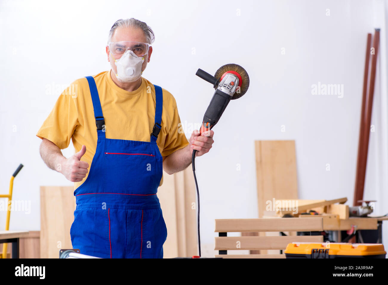 The old male carpenter working in workshop Stock Photo - Alamy