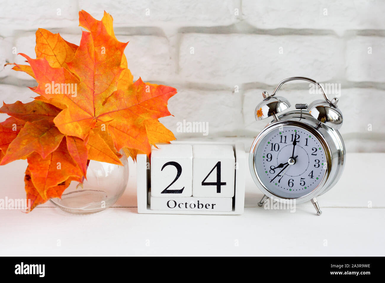 October 24 on a wooden calendar next to the alarm clock, the date of ...