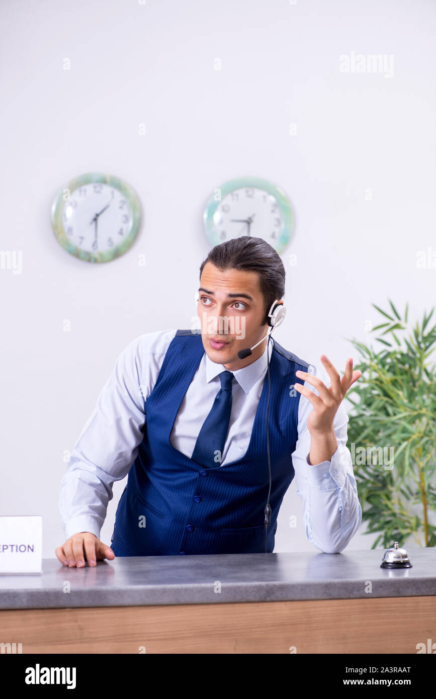 The young man receptionist at the hotel counter Stock Photo - Alamy