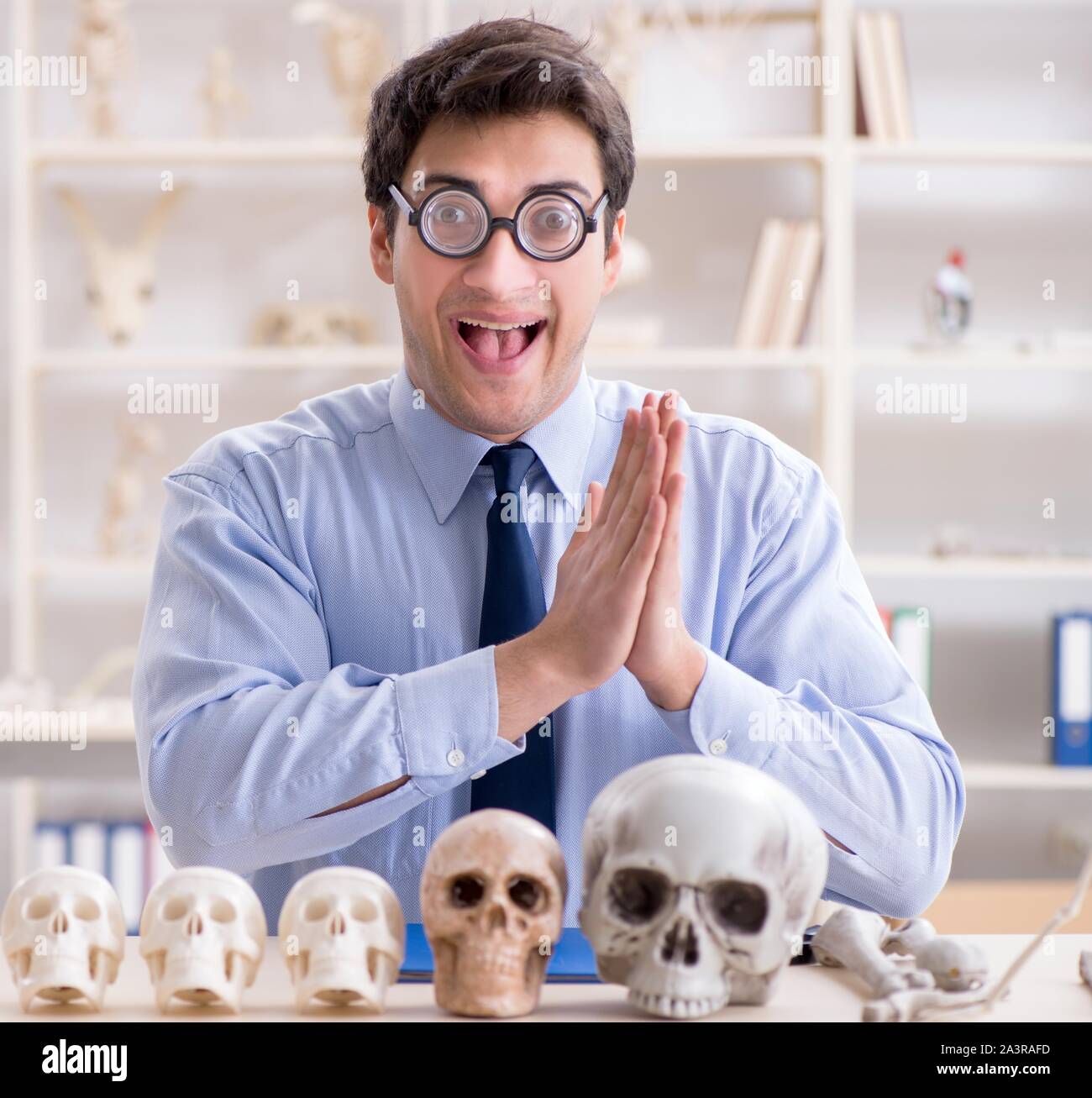 The funny crazy professor studying human skeleton Stock Photo - Alamy