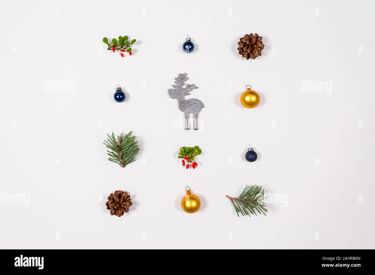 Creative flat lay of winter toys, deer, balls and cones on white ...