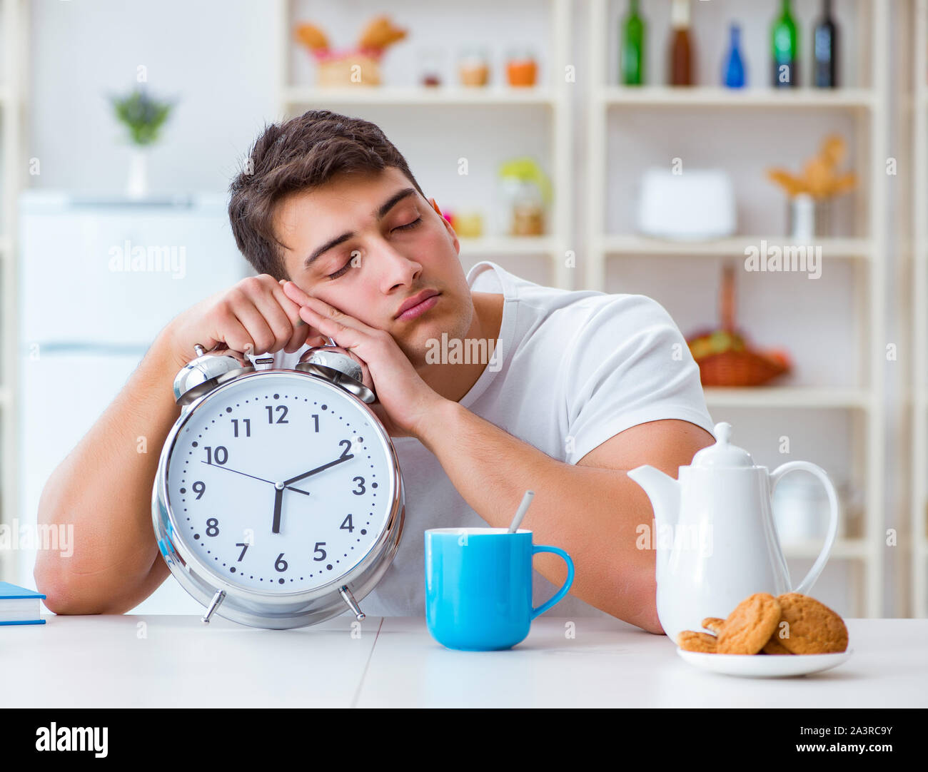 The man with alarm clock falling asleep at breakfast Stock Photo - Alamy