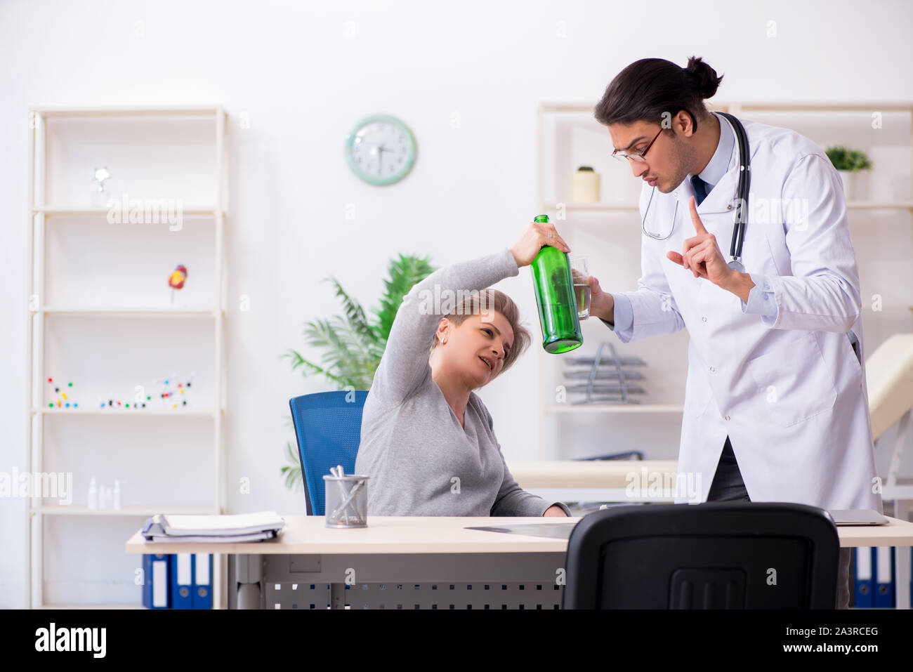 The female alcoholic visiting young male doctor Stock Photo - Alamy
