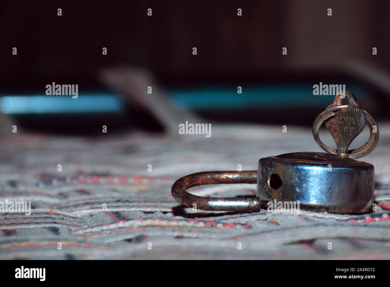 The old lock and key on abed of clothes with blur and black background ...