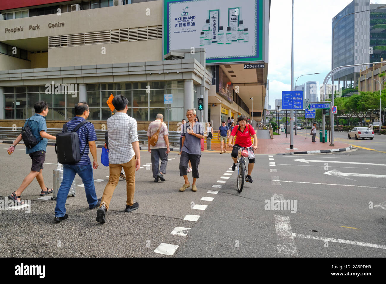 Pedestrians and a cyclist crossing Upper Cross Street in Chinatown ...