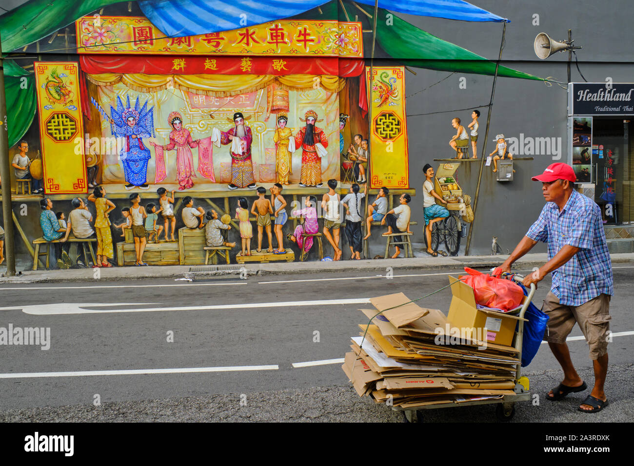 A man passes a wall painting by artist Yip Yew Chong, depicting a ...