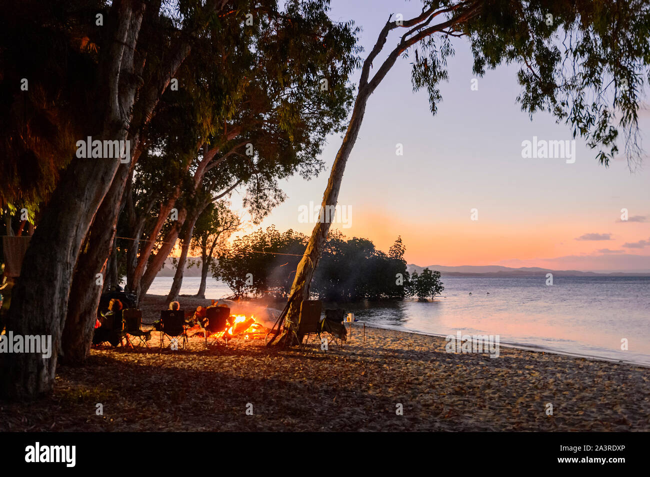 People around a campfire by the beach at sunset, Elim Beach, near ...