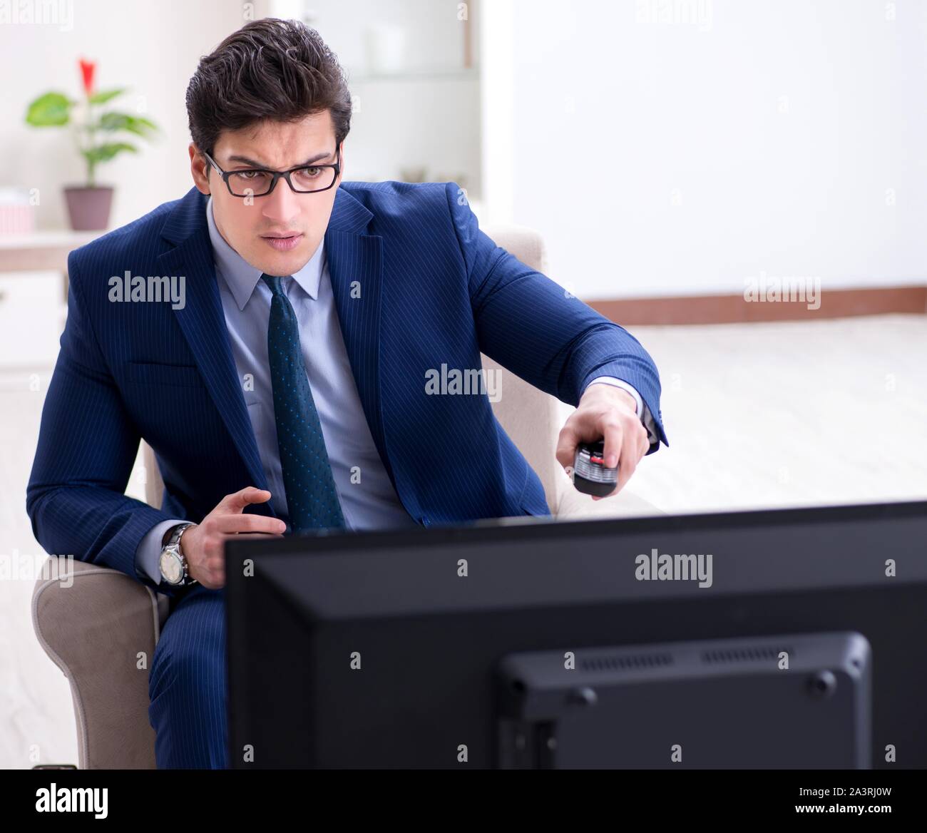 The businessman watching tv in the office Stock Photo - Alamy