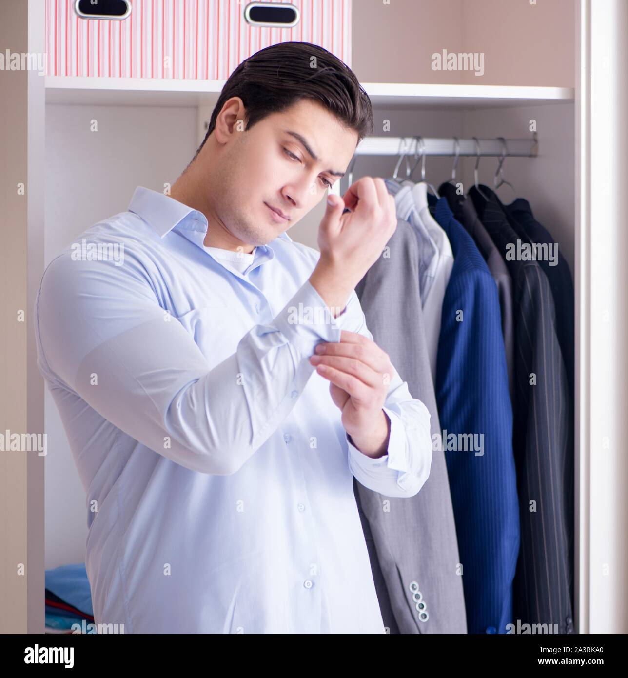 The young man businessman getting dressed for work Stock Photo - Alamy