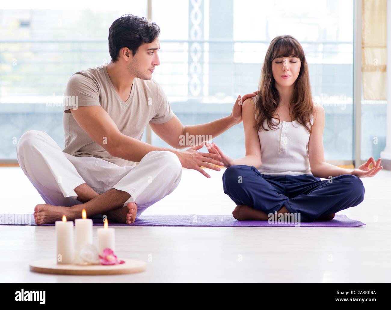 The personal coach helping during yoga session Stock Photo - Alamy
