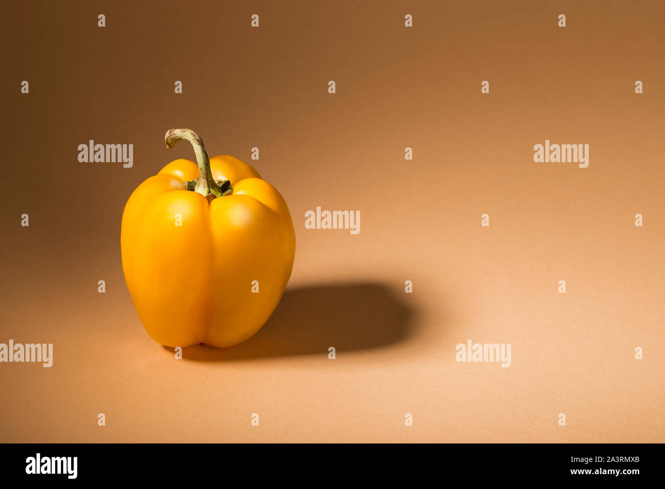 Big yellow paprika isolated on light brown background Stock Photo - Alamy