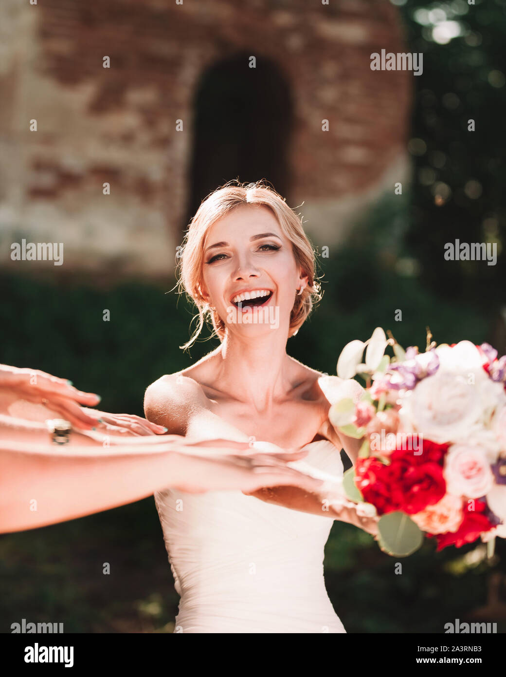 sweet bride passing wedding bouquet in the hands of her friends Stock ...