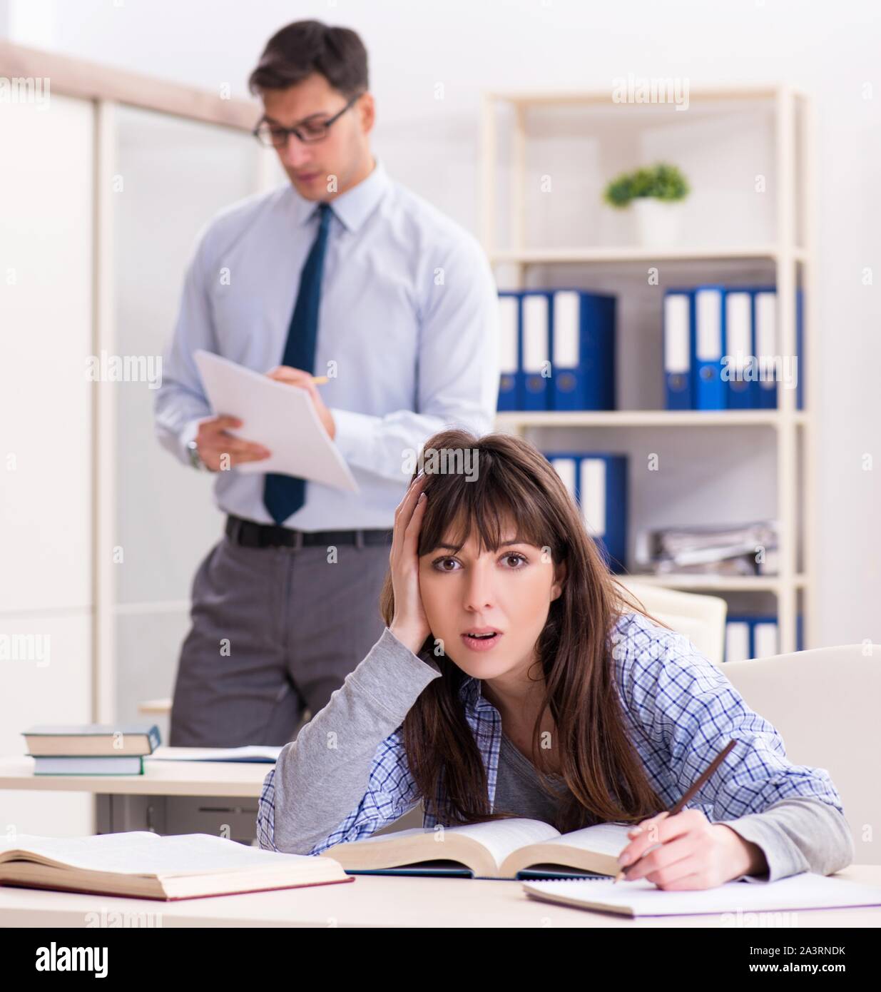 The male lecturer giving lecture to female student Stock Photo - Alamy