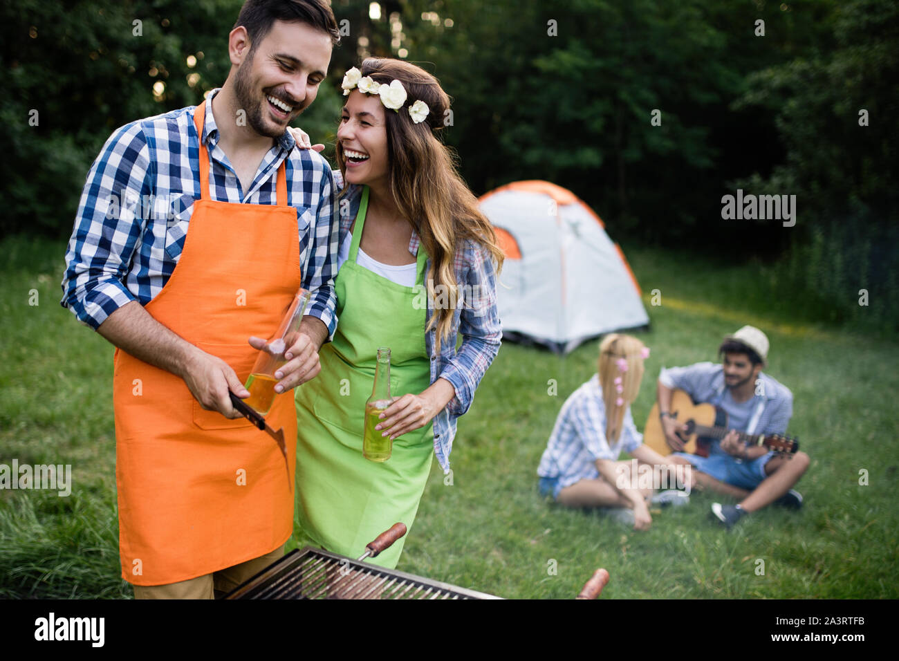 Group of friends making a barbecue together outdoors in the nature ...