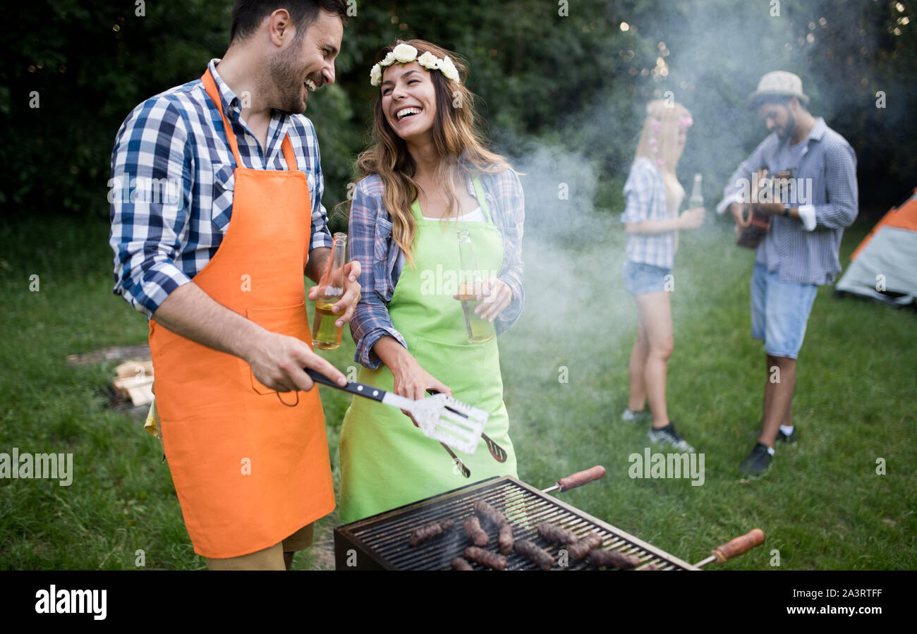 Group of friends making a barbecue together outdoors in the nature ...