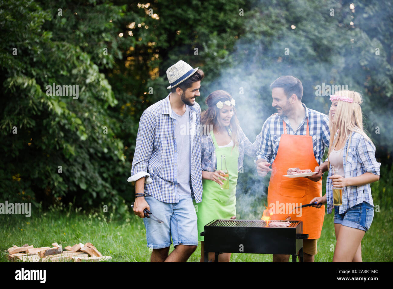 Group of friends making a barbecue together outdoors in the nature ...