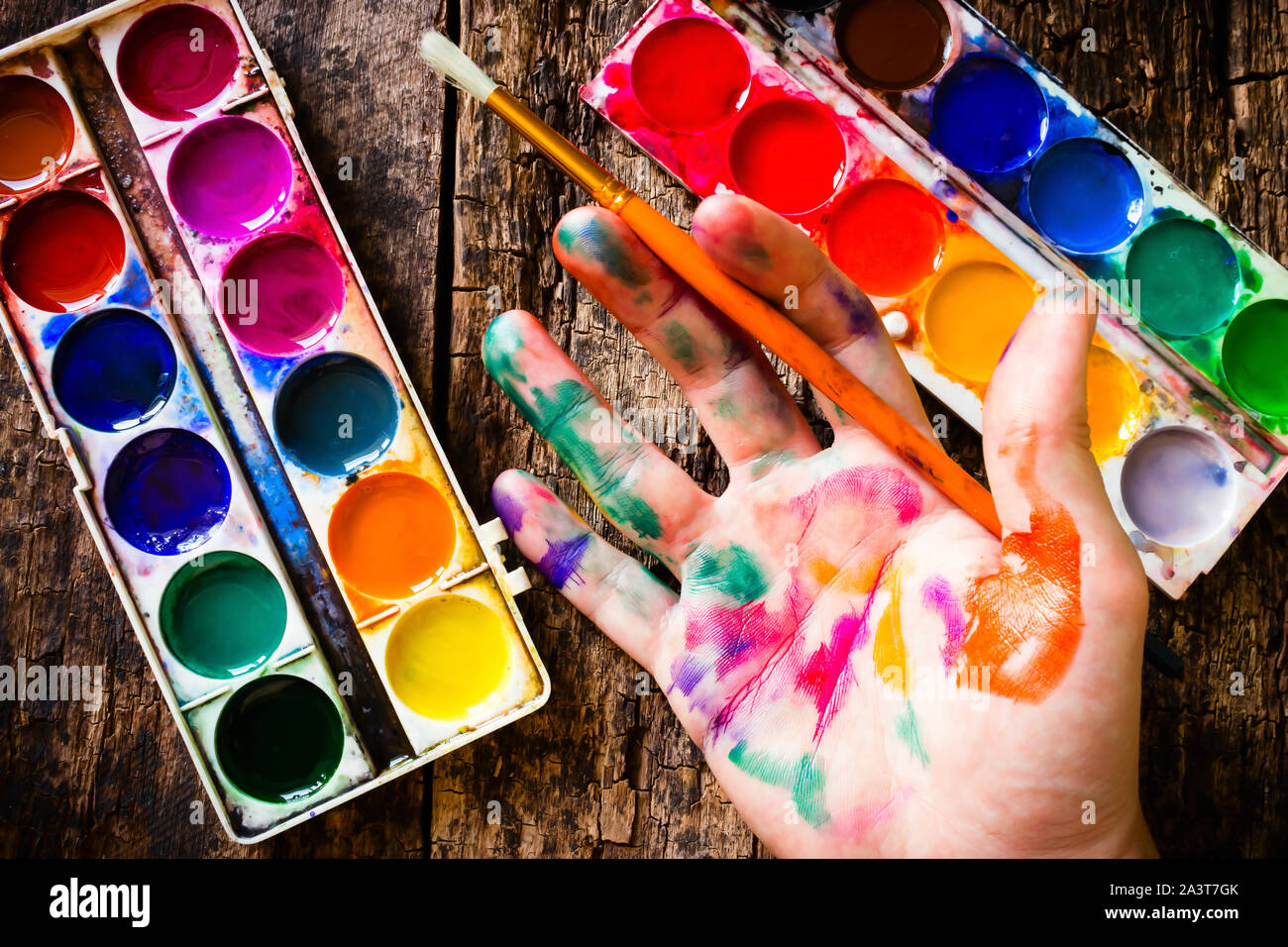 watercolor paint brush to paint the hand of the artist in multi-colored ...