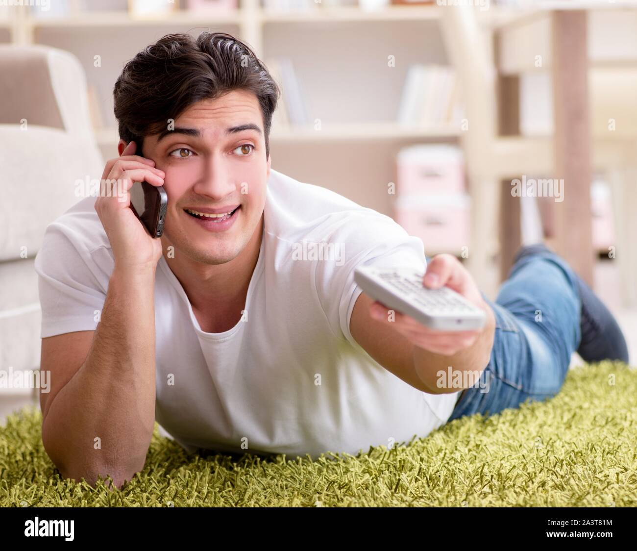 The man watching tv at home on floor Stock Photo - Alamy