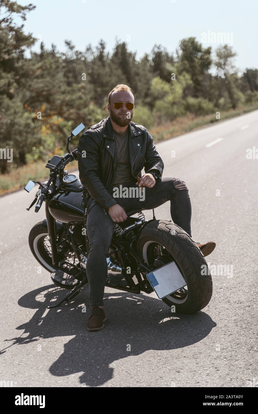 Attractive bearded biker sitting backwards on the motorcycle Stock ...