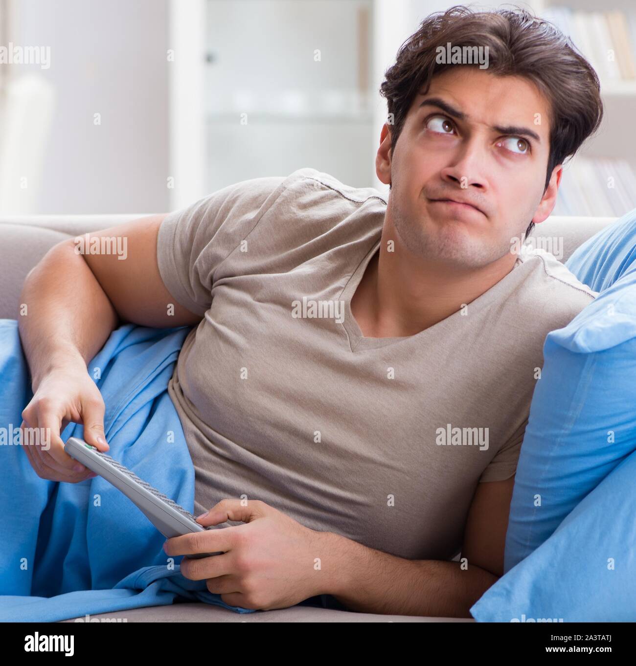 The man watching tv from bed holding remote control unit Stock Photo ...