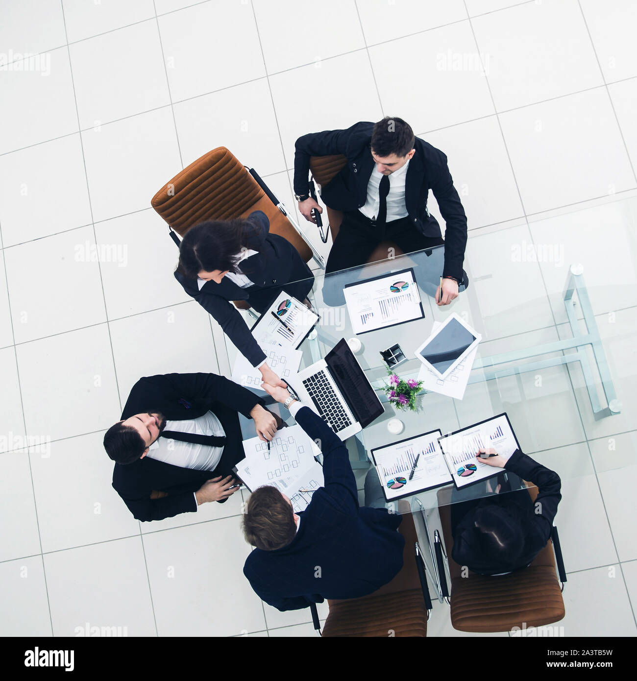 business partners shaking hands after a discussion of the new fiscal ...