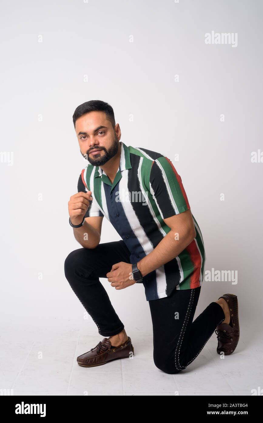 Full body shot of young bearded Indian man crouching Stock Photo - Alamy