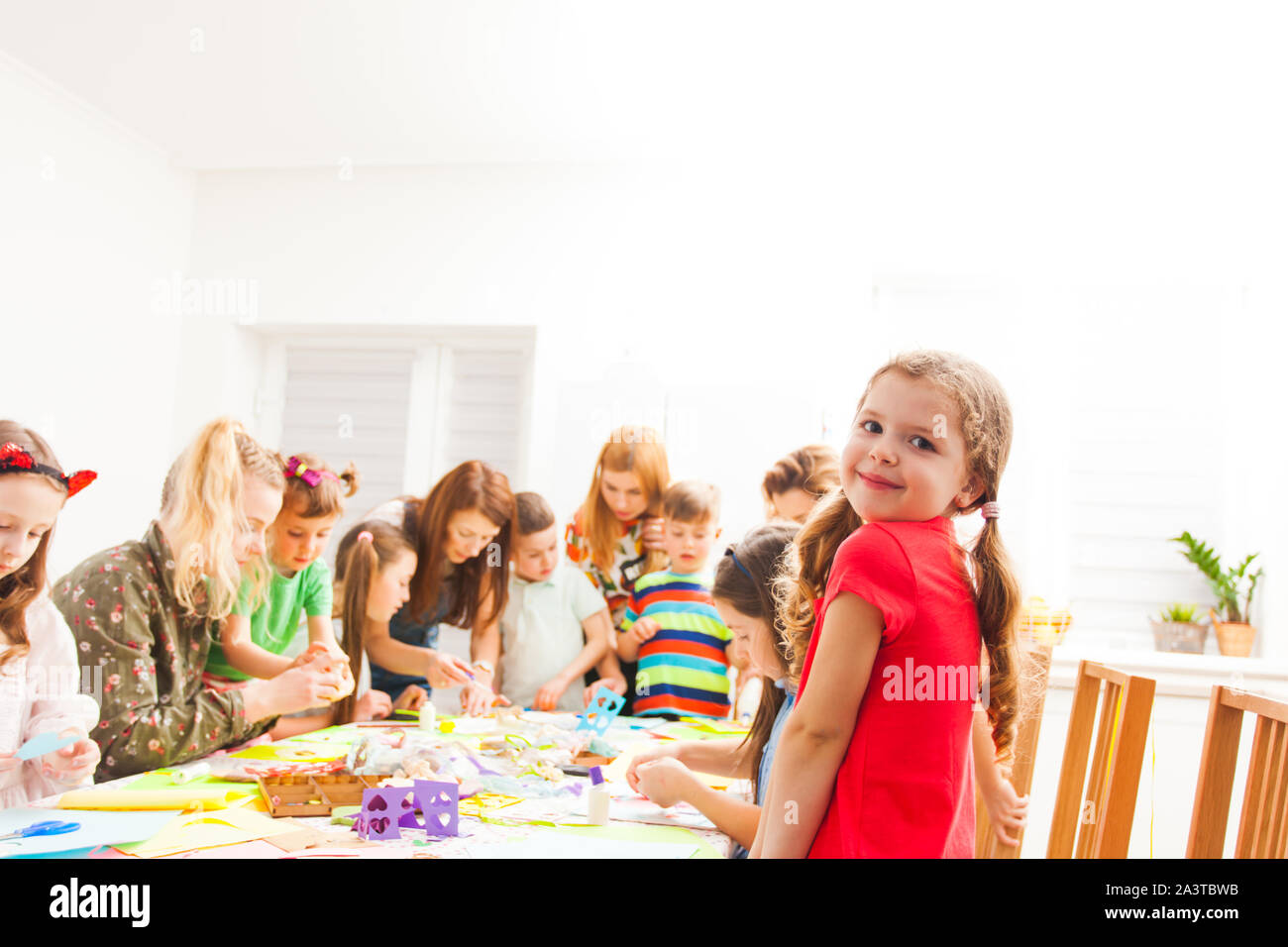 Kids making some paper crafts with teacher at workshop Stock Photo - Alamy