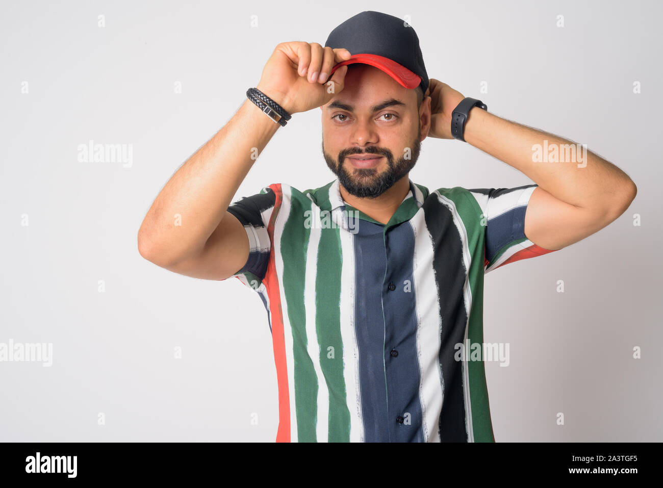 Portrait of young handsome bearded Indian man wearing hat Stock Photo ...