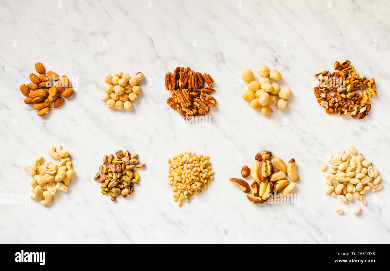 Heaps of various types of nuts on the white marble background Stock ...