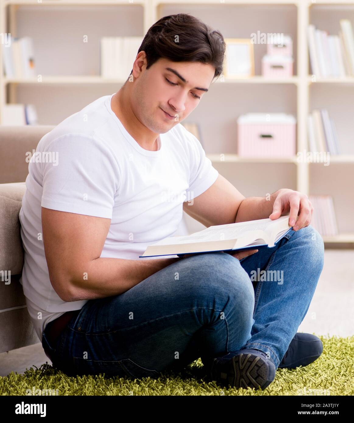 The man reading book at home on floor Stock Photo - Alamy