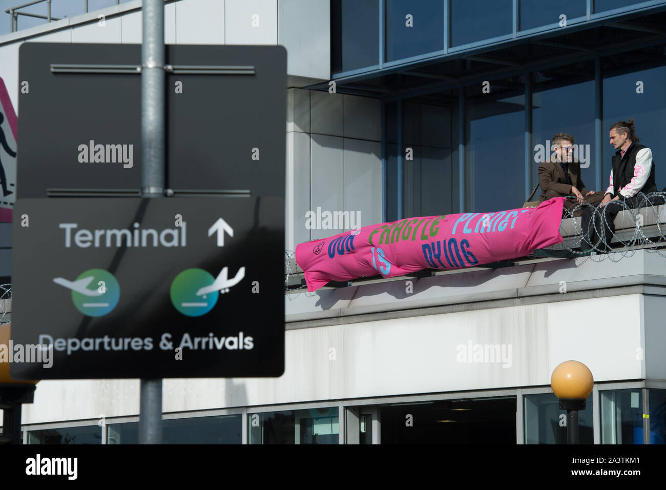 Protesters on the roof of the terminal building at City Airport, London ...