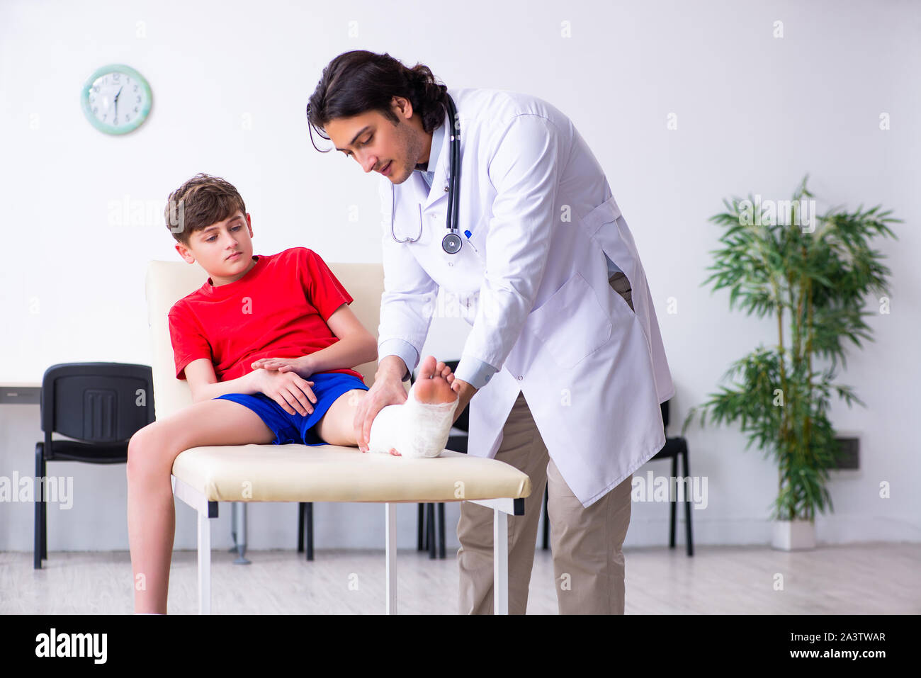 The leg injured boy visiting young doctor traumatologist Stock Photo ...