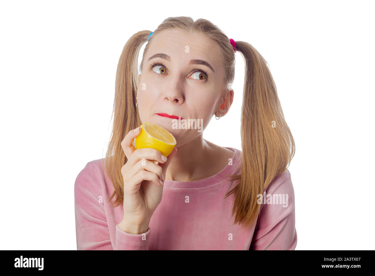 beautiful fun girl with lemon posing on white background, eats it ...