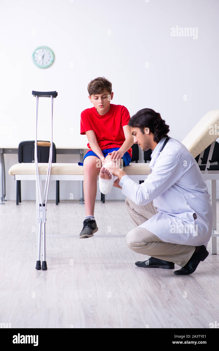 The leg injured boy visiting young doctor traumatologist Stock Photo ...