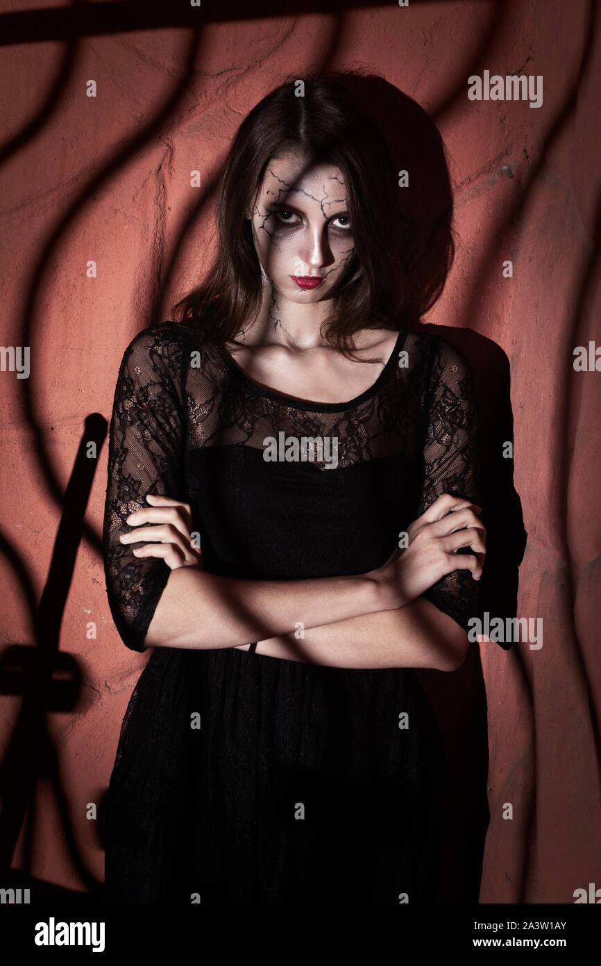 scared serious young woman with halloween makeup looking at camera ...