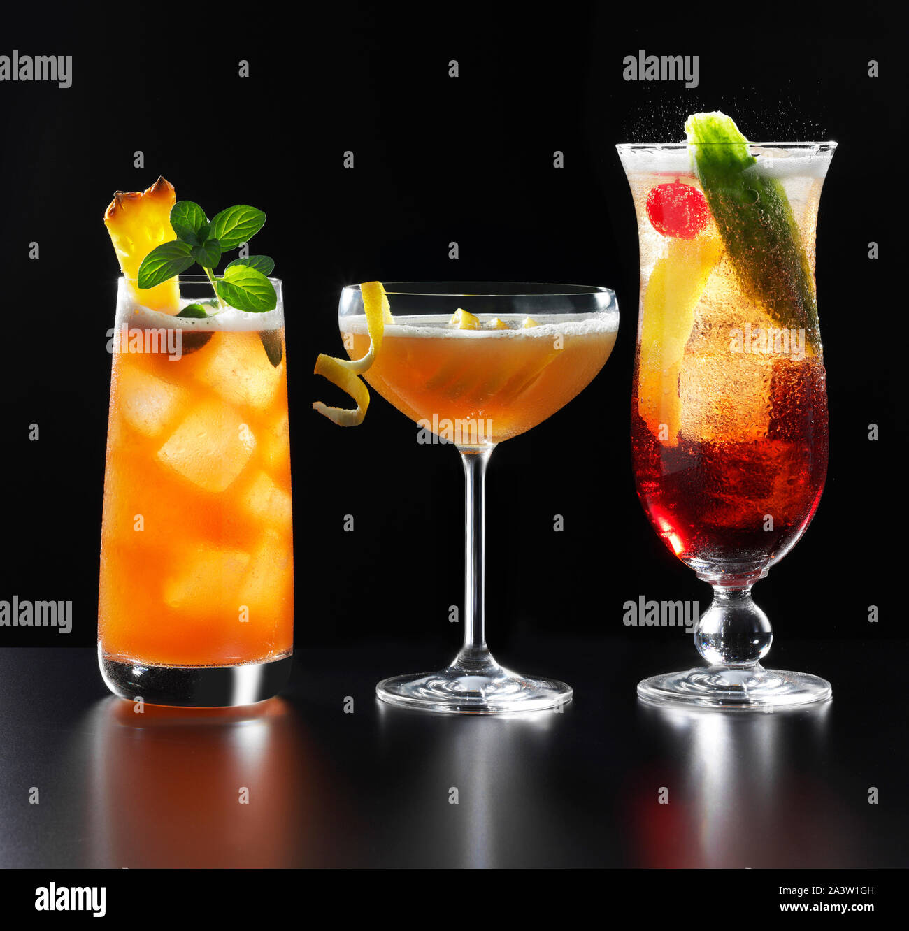 three cocktails against black background Stock Photo - Alamy