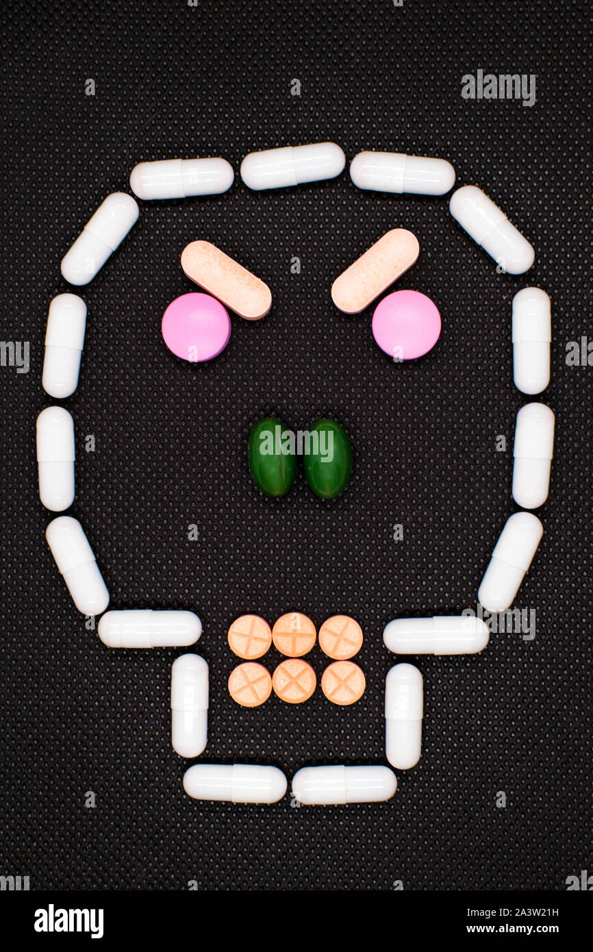 different colors and shapes of medical tablets lined in the form of a ...