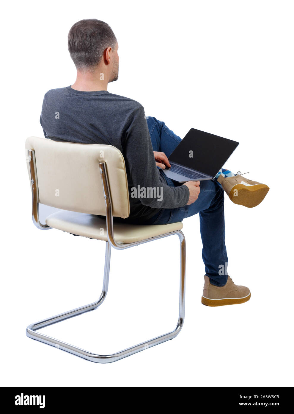 Back view of a man who sits on a chair with a laptop. Rear view people ...