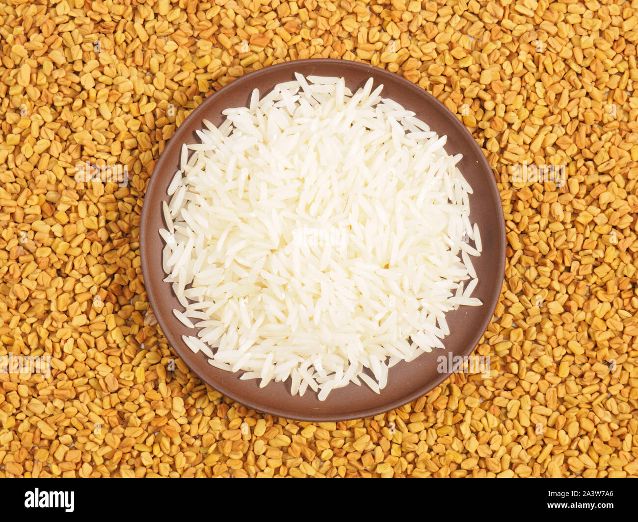 Basmati rice in clay plate. Background from Fenugreek. Indian cuisine ...